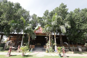 Um edifício com design tradicional, rodeado por vegetação exuberante e palmeiras.