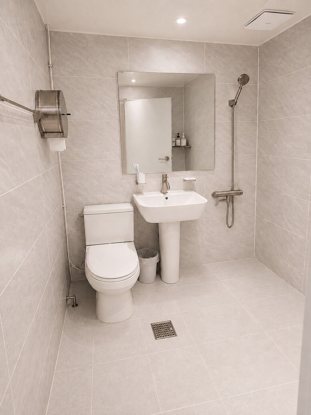 Uma casa de banho moderna com sanita, lavatório e chuveiro.