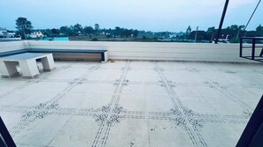 Um terraço no terraço com piso estampado, área de estar e vista para a paisagem ao redor.