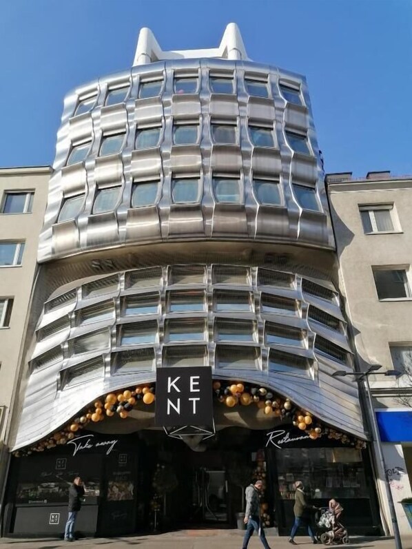 Um edifício moderno com fachada curva e um letreiro em destaque com a palavra 'KENT'.