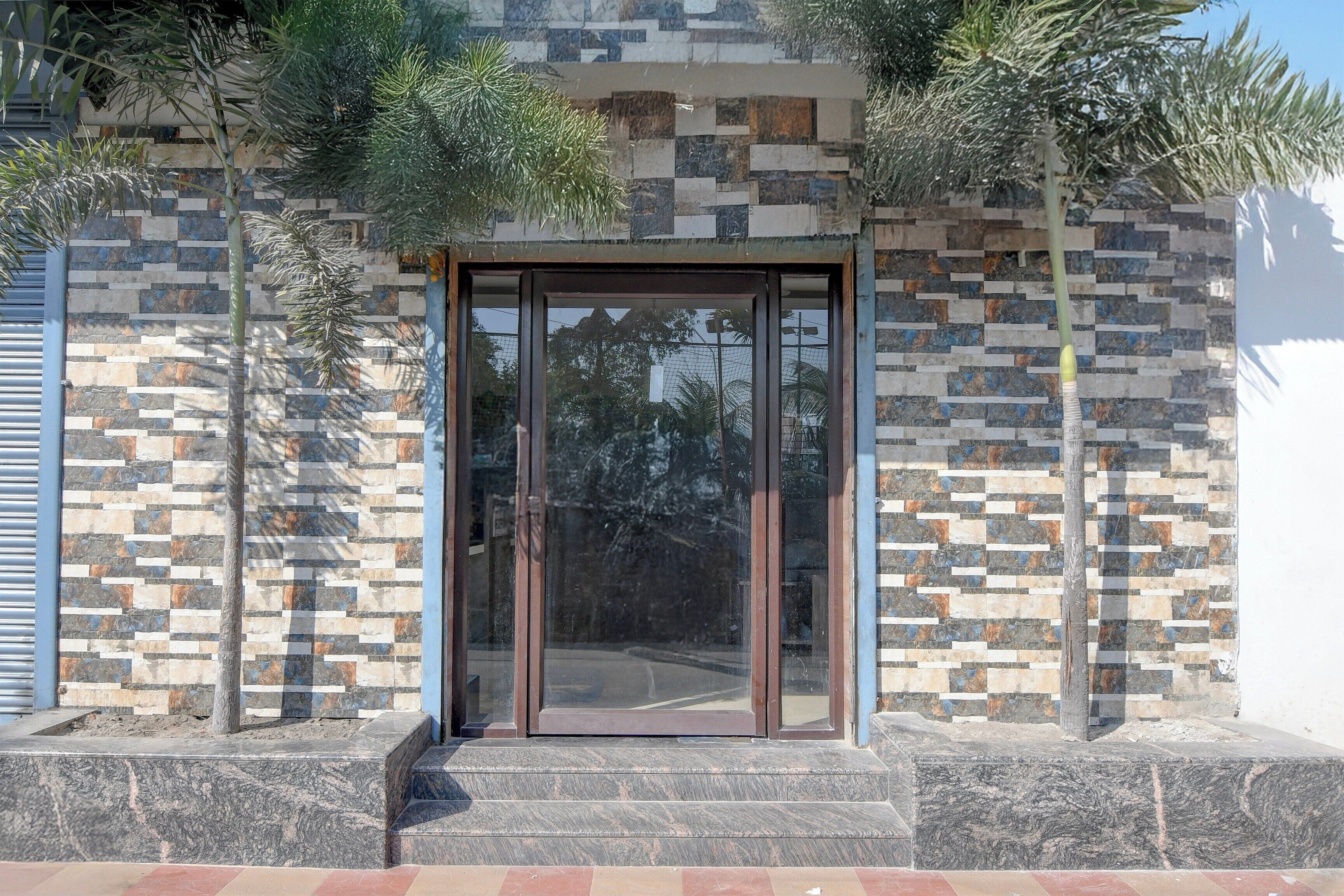 Entrada de um edifício com porta de vidro e fachada de pedra.