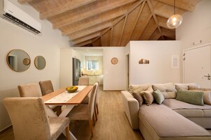 Um interior moderno com área de jantar, sofá e cozinha visíveis através de uma porta aberta.
