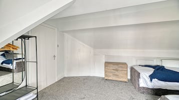 Quarto com cama beliche, guarda-roupa, cômoda de madeira e radiador.