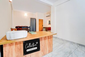 Bancada de recepção de hotel com sinal indicando ponto de coleta de encomendas corporativas.