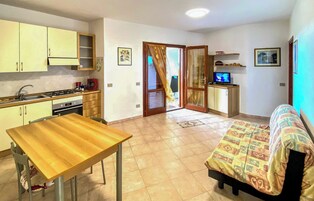Um espaço compacto com cozinha compacta, área de refeições e quarto com cama.
