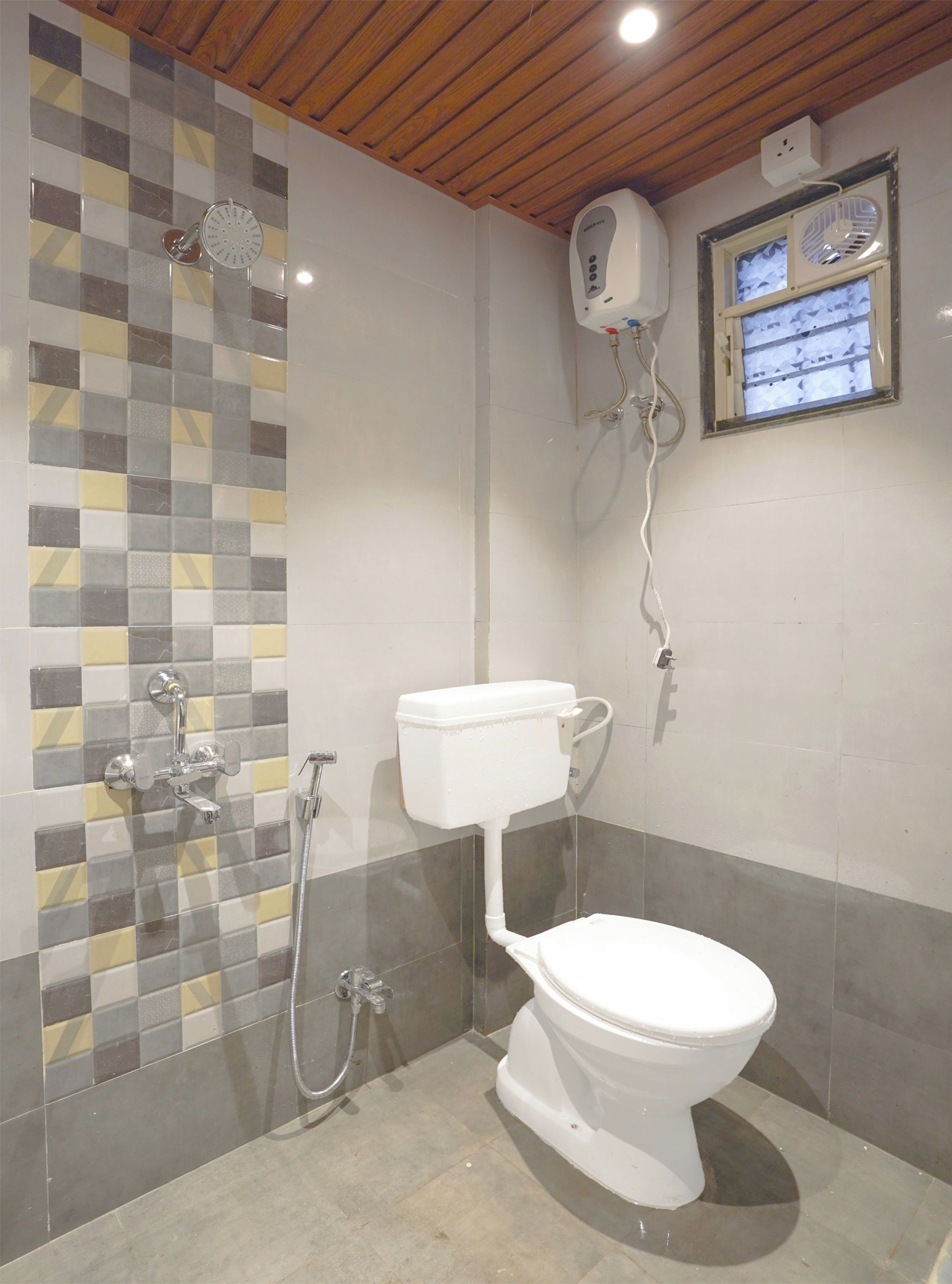 Casa de banho com chuveiro, sanita e purificador de ar fixado na parede.