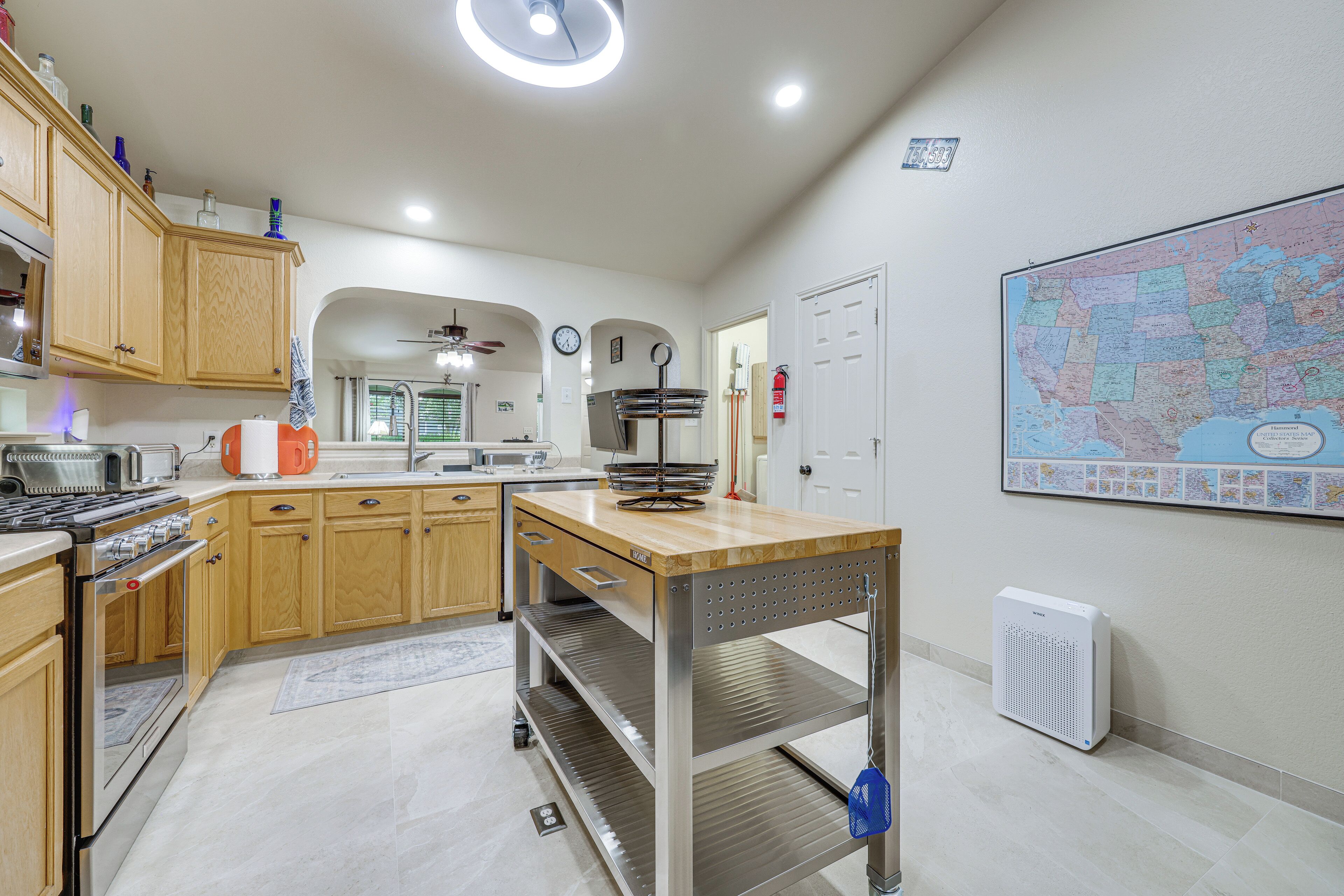 Cozinha moderna com armários de madeira, eletrodomésticos de aço inoxidável e uma ilha central.