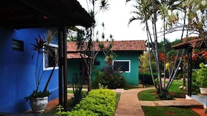 Um pátio com um caminho que leva a um edifício com telhado de telhas vermelhas.