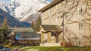 Um hotel com vista para as montanhas, área externa coberta e estacionamento.