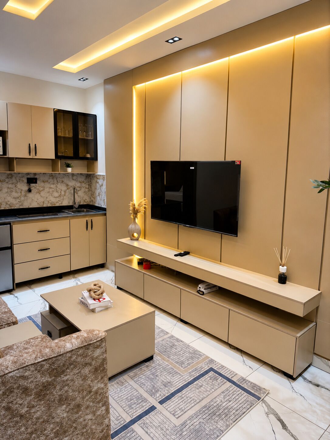 Cozinha moderna com eletrodomésticos embutidos, televisão de tela plana e painel de fundo de mármore.