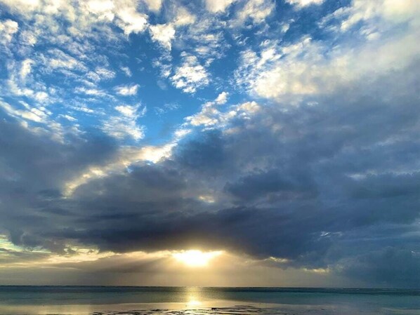 Uma praia com vista para o oceano e um céu nublado.