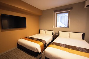 Quarto de hotel com duas camas, uma televisão de tela plana fixada na parede e uma janela com vista para o exterior.