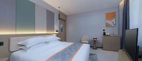 Quarto de hotel moderno com uma cama grande, uma escrivaninha, uma cadeira, uma televisão e uma mesinha.