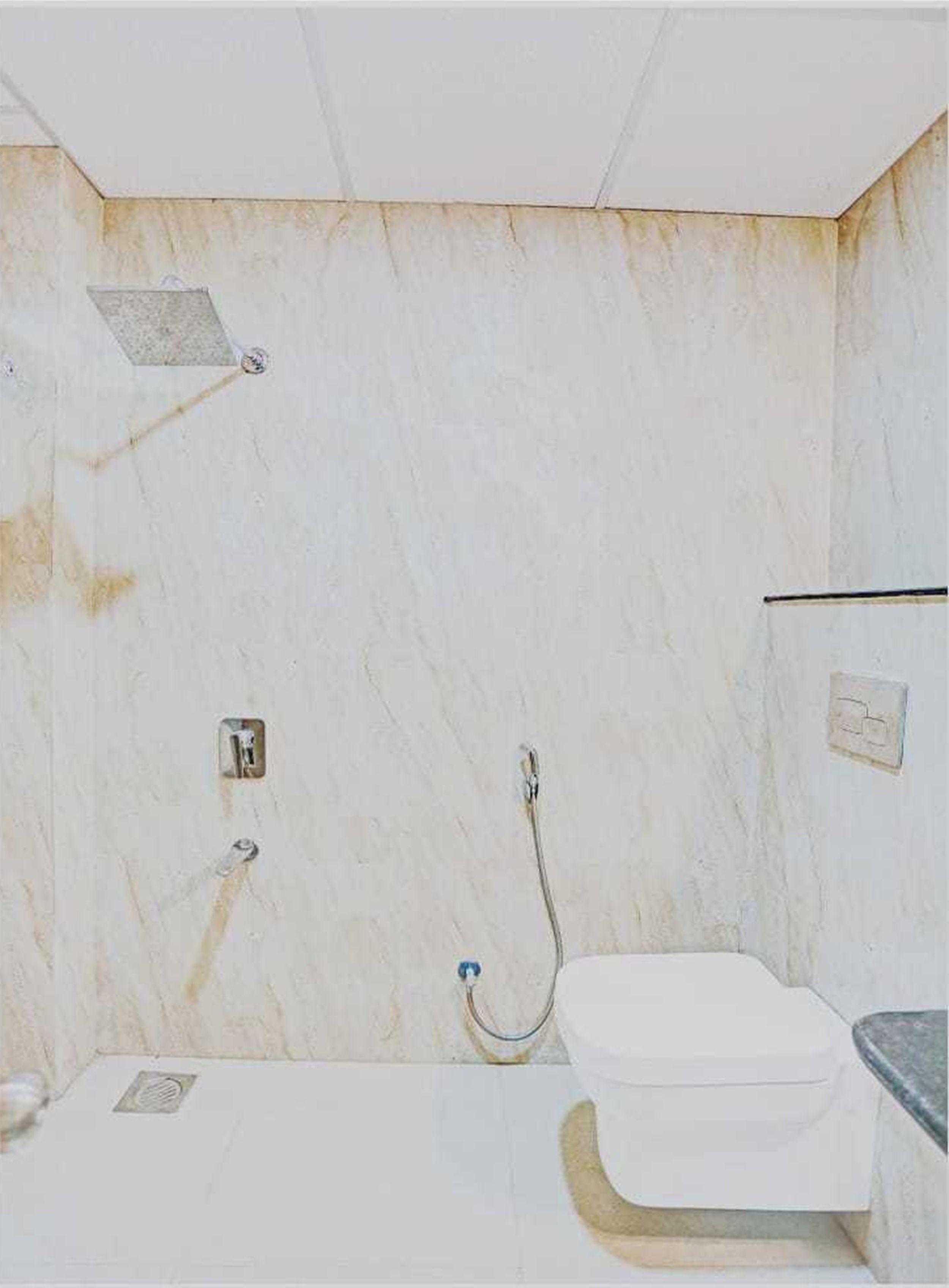 Uma casa de banho com chuveiro, sanita e lavatório.