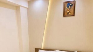 Uma cama bem arrumada com lençóis brancos e três pétalas de rosa vermelhas sobre ela.