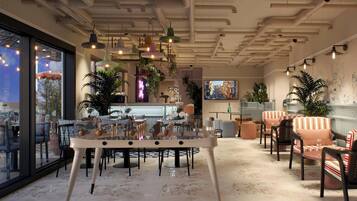 Um interior moderno com uma mesa de vidro, assentos e vista para uma rua da cidade.