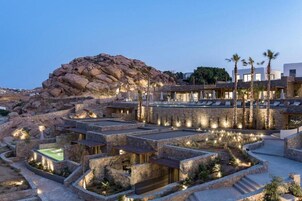 Resort com arquitetura em pedra, área de estar ao ar livre e piscina.