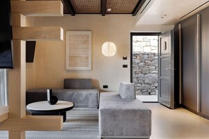 Um interior moderno com um sofá, uma mesa redonda e uma luminária pendente.