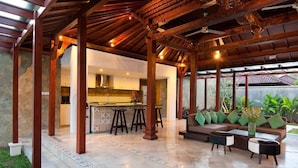 Uma sala de estar integrada com cozinha, bar e área de estar com sofá e mesa de centro.