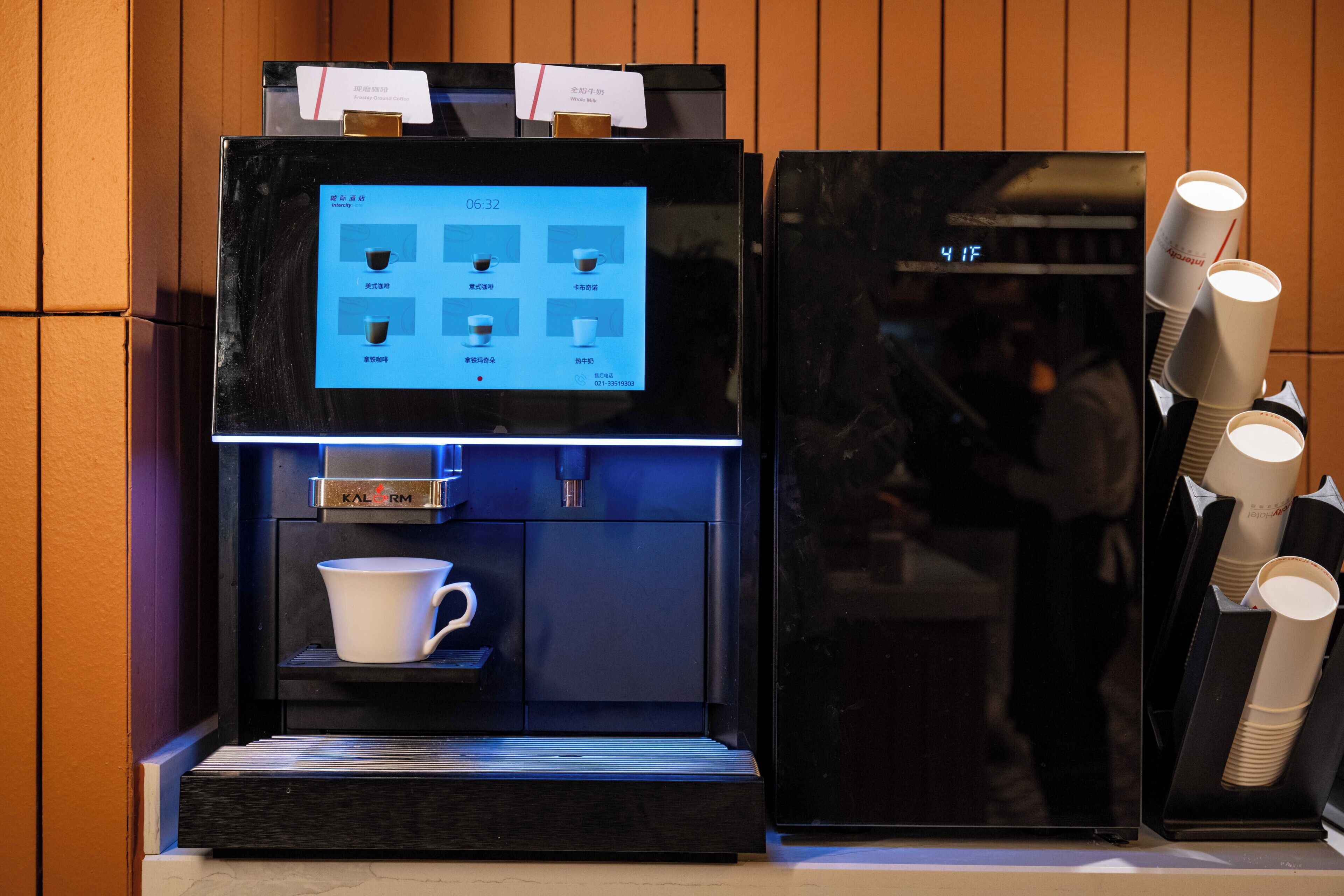 Máquina de café com visor digital, suporte para chávena e dispensador de café.