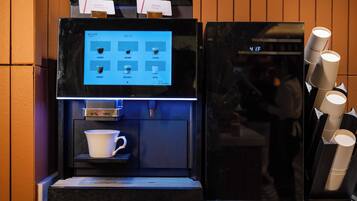 Máquina de café com visor digital, suporte para chávena e dispensador de café.