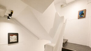 A staircase with a handrail, a light fixture, and a framed picture on the wall.