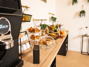 Um buffet de café da manhã com croissants, pão e frutas.