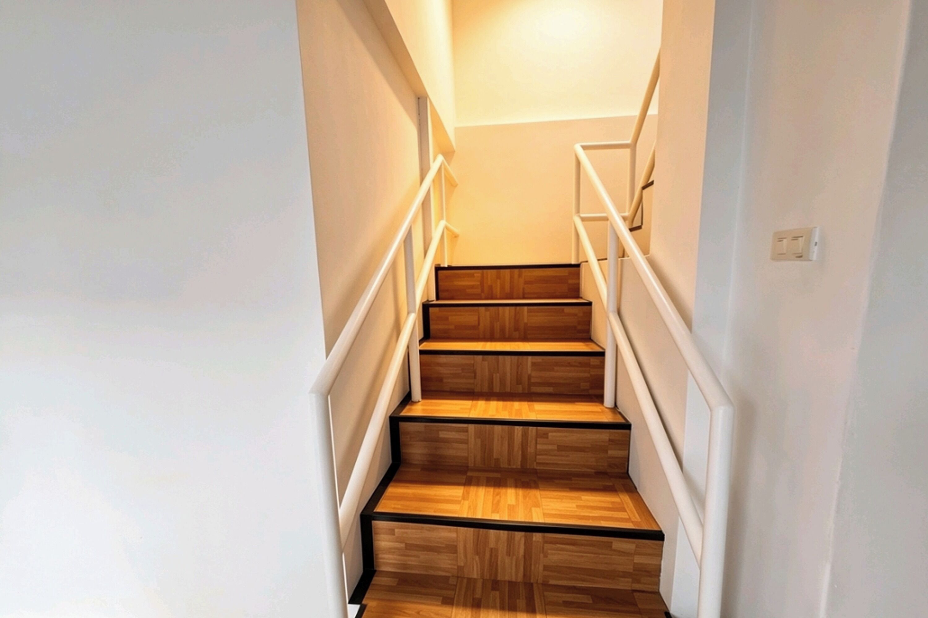 A staircase with wooden steps and white railings.
