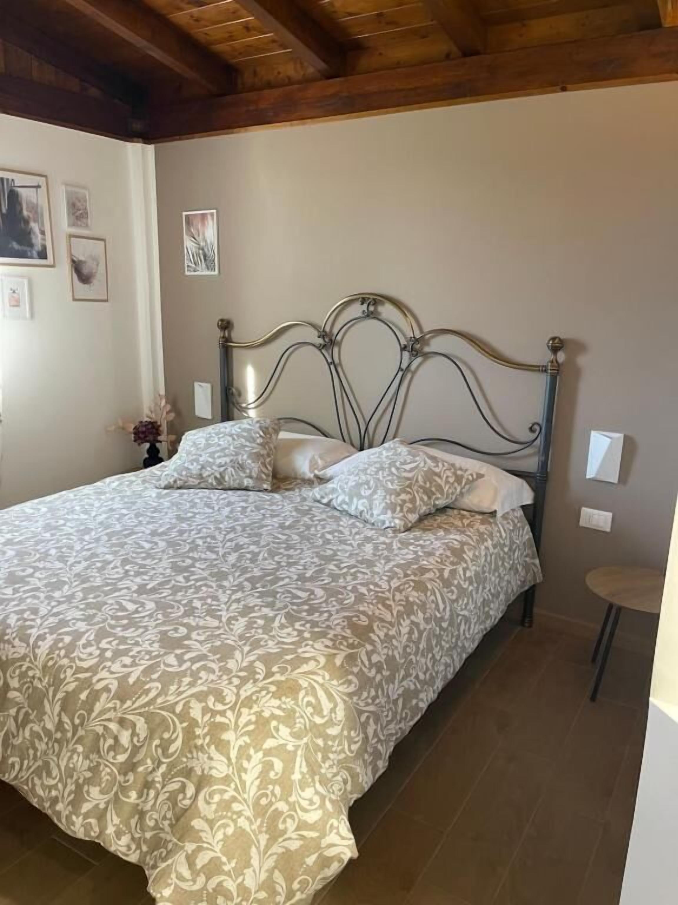 Quarto com cama, mesa de cabeceira e interruptor de luz na parede.