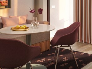 Uma área de refeições moderna com uma mesa redonda, duas cadeiras, um vaso com flores e um prato com limões.