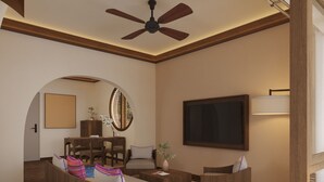 Uma sala de estar moderna com uma mesa de centro, área de estar e um ventilador de teto.