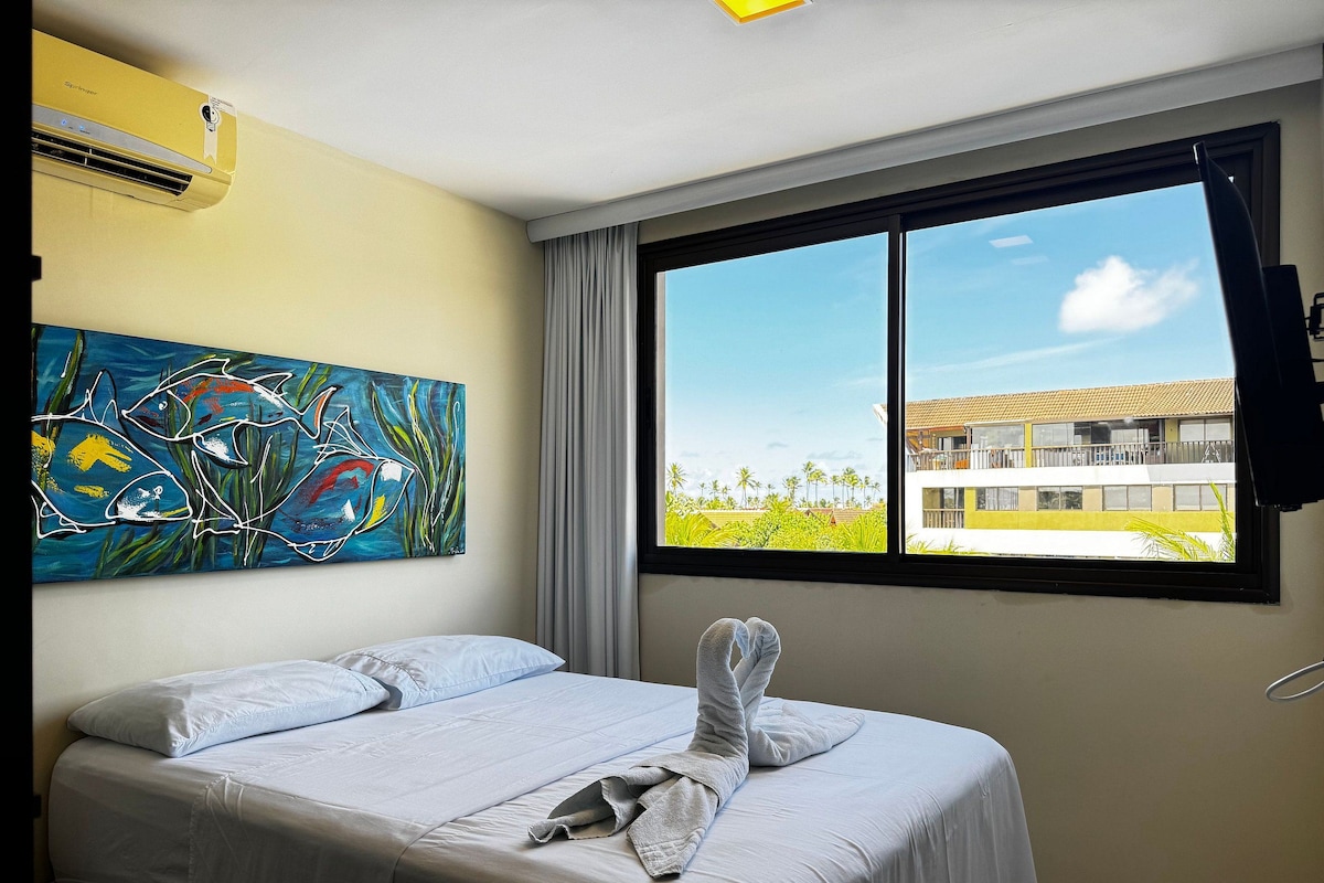 Quarto de hotel com cama, um quadro, janela com vista e ar condicionado.