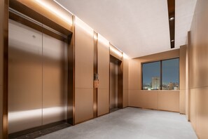 Um elevador moderno com vista para a cidade através de uma janela.