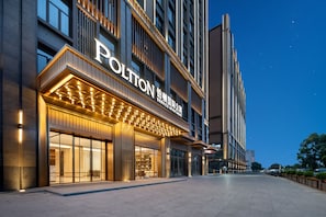 Um edifício moderno com uma placa de destaque que diz 'POLTON SERVICE APARTMENT'.