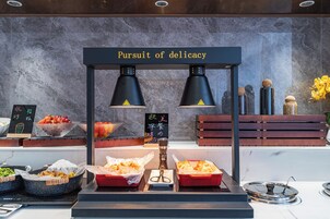 Disposição de buffet com um letreiro que diz 'Pursuit of delicacy', apresentando diversos alimentos e acompanhamentos.