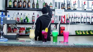 Bar com variedade de garrafas e aviso de que não aceita cartão de crédito.