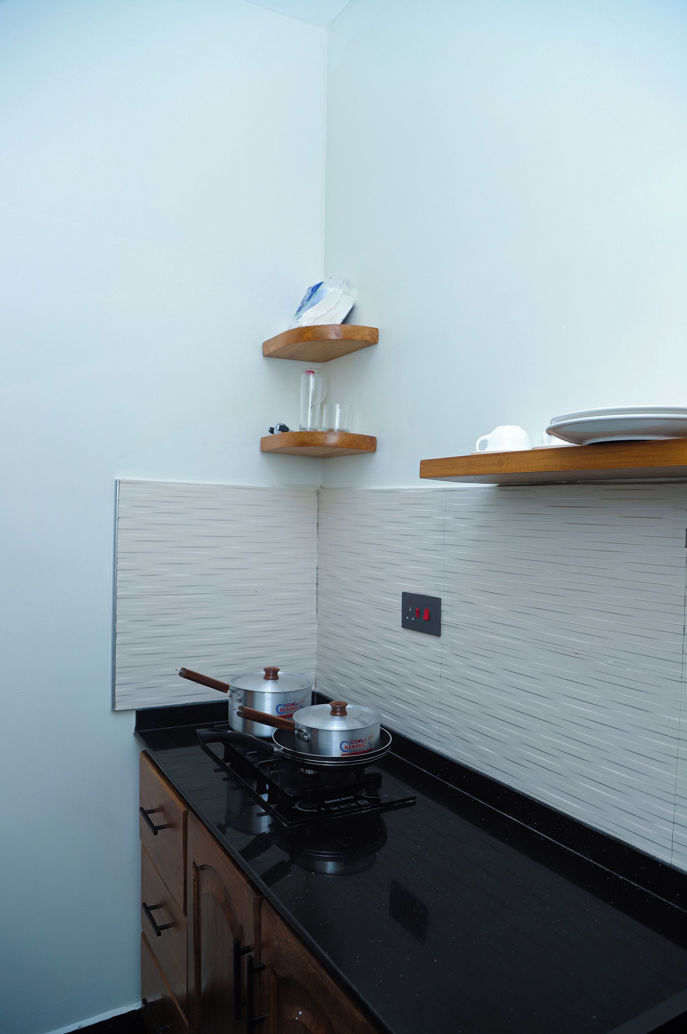Uma cozinha compacta com bancada preta, fogão e armários de madeira.