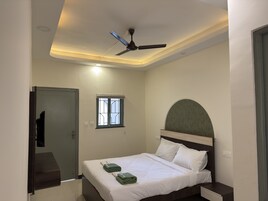Quarto com cama, ventoinha no teto, janela e porta.