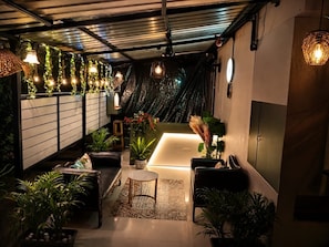 Um interior moderno com área de estar, uma mesinha e uma parede decorativa com plantas.