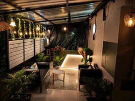 Um interior moderno com área de estar, uma mesinha e uma parede decorativa com plantas.