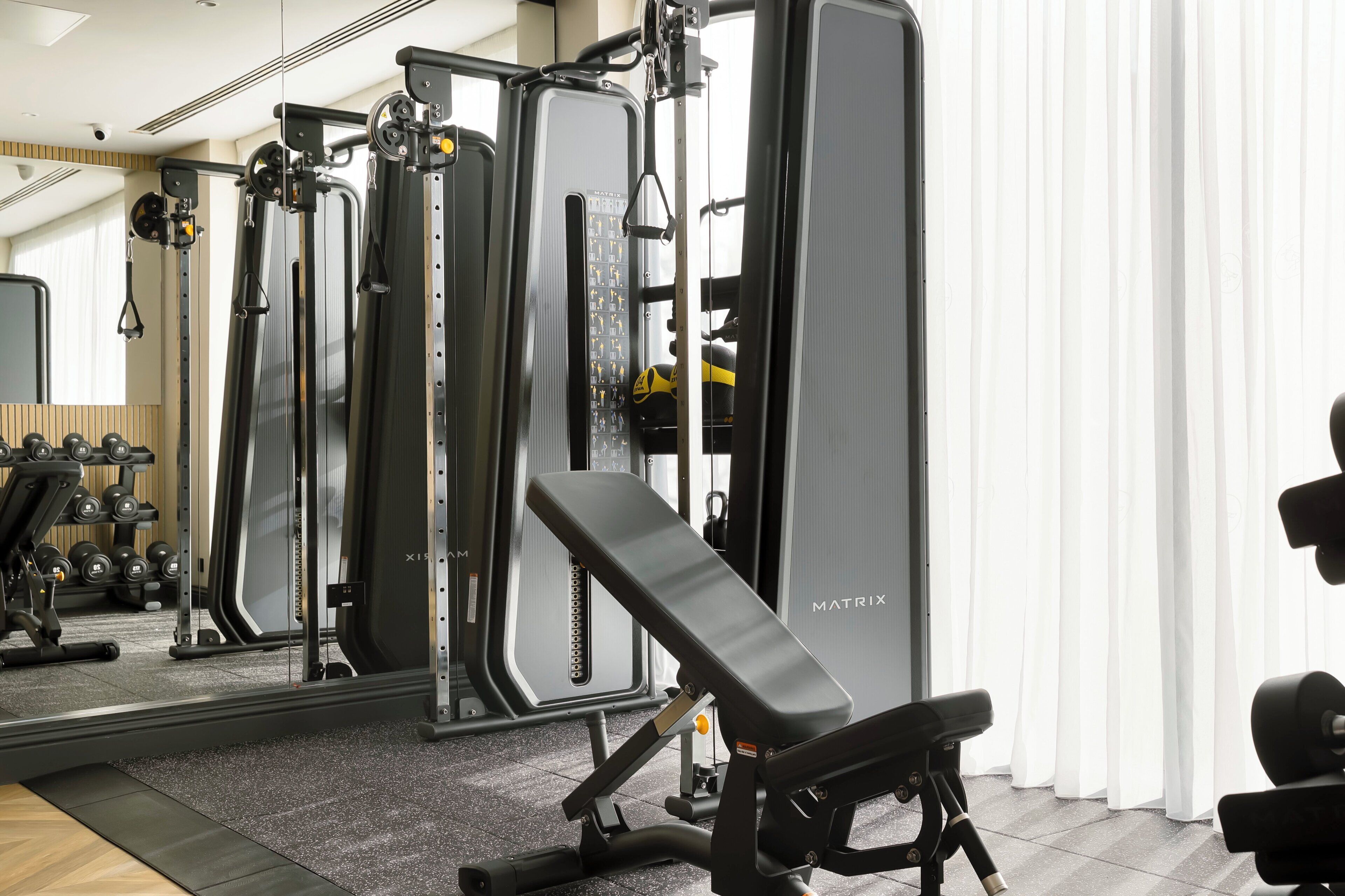Uma academia com diversos equipamentos de exercício, incluindo aparelhos de musculação e halteres.