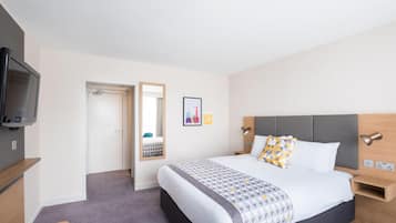 Quarto de hotel com cama, mesas de cabeceira, televisão, espelho e um quadro na parede.
