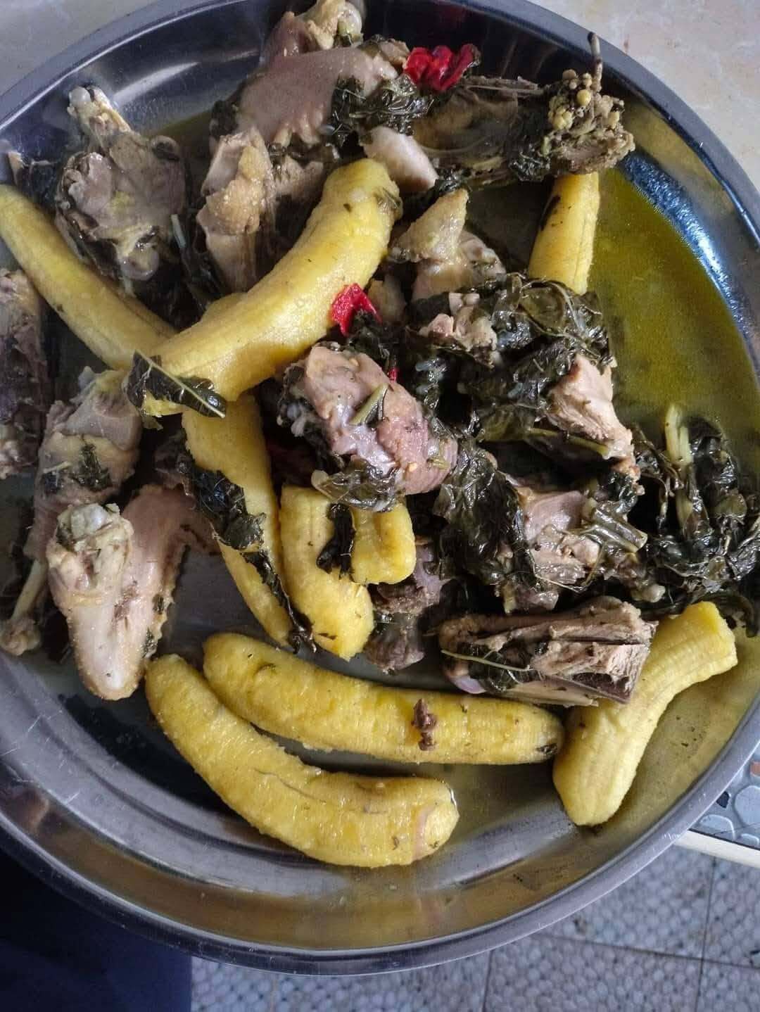 Prato com frango, folhas verdes e legumes amarelos em uma tigela de metal.