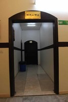Um corredor com uma porta identificada como 'Y17-Y10' e uma placa de 'SAÍDA' na parede.