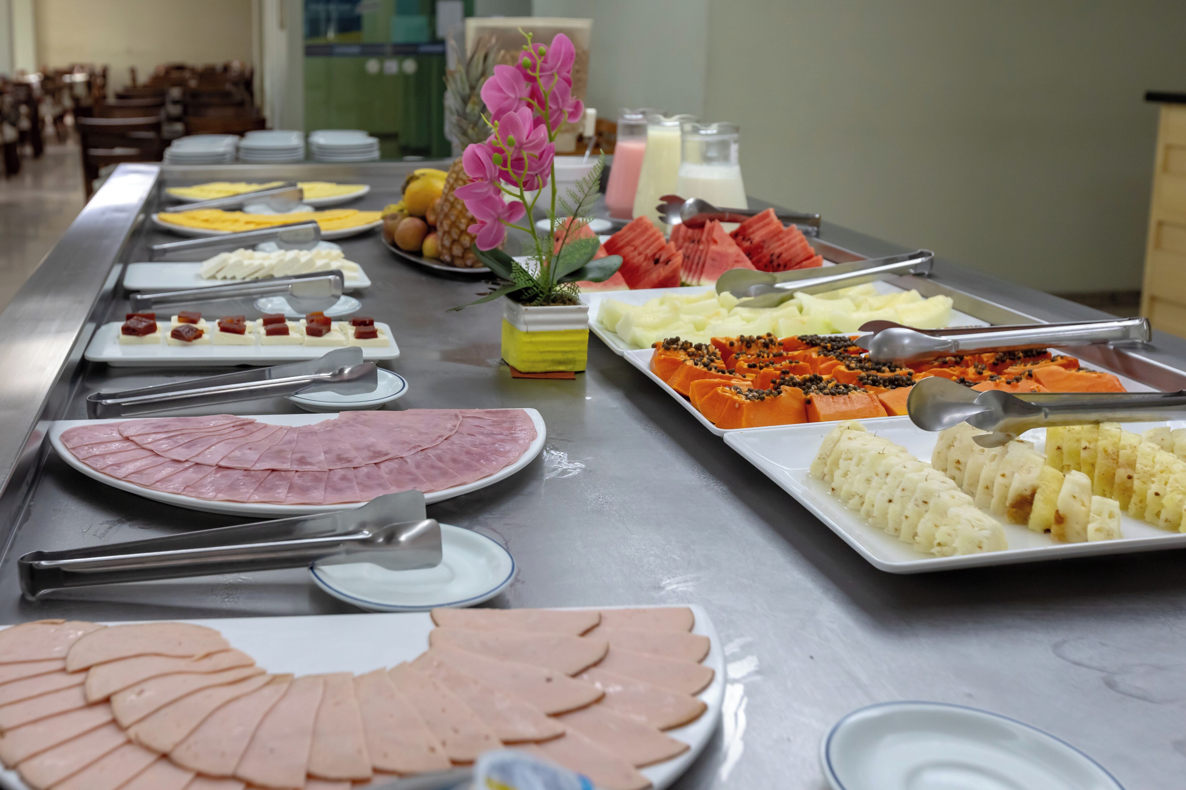 Buffet com diversos alimentos e utensílios.