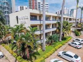 Hotel com design moderno, apresentando um telhado plano e várias varandas.