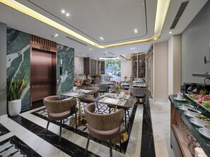 Um hall de hotel moderno com piso de mármore, balcão de recepção, área de estar e buffet.