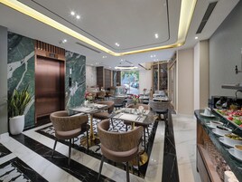 Um hall de hotel moderno com piso de mármore, balcão de recepção, área de estar e buffet.