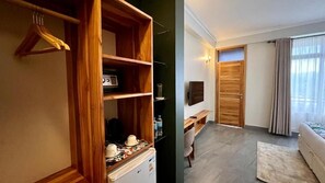 Um quarto com armário de madeira, escrivaninha, cadeira e cama.