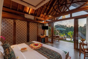 Quarto de hotel com cama, escrivaninha e vista para o exterior.